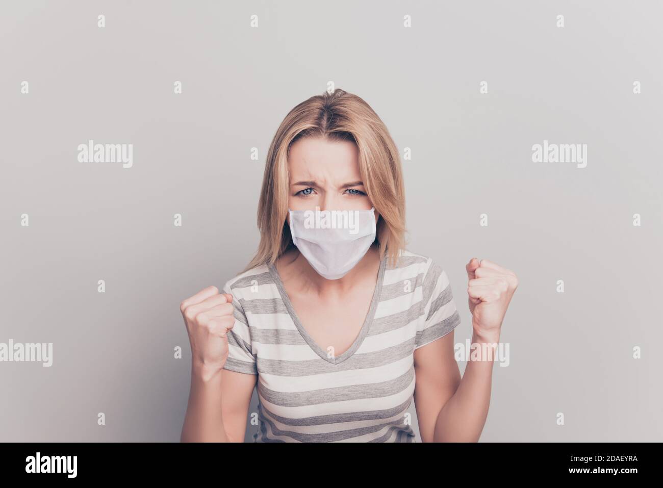 Close up portrait of furious woman showing fists wearing white face ...