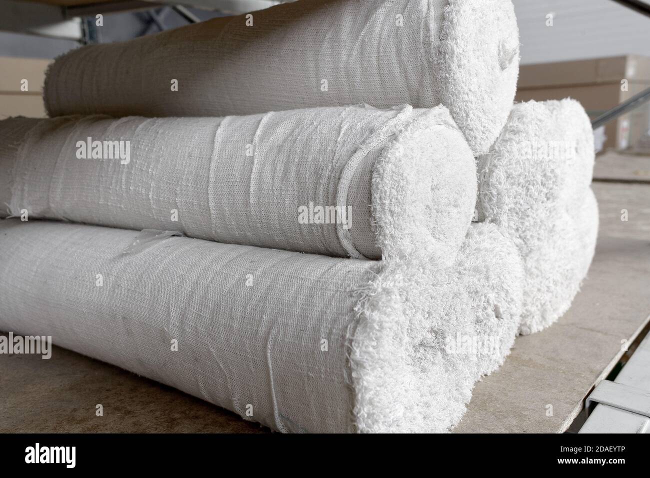 White material in rolls is on the shelves of the warehouse. Covering ...