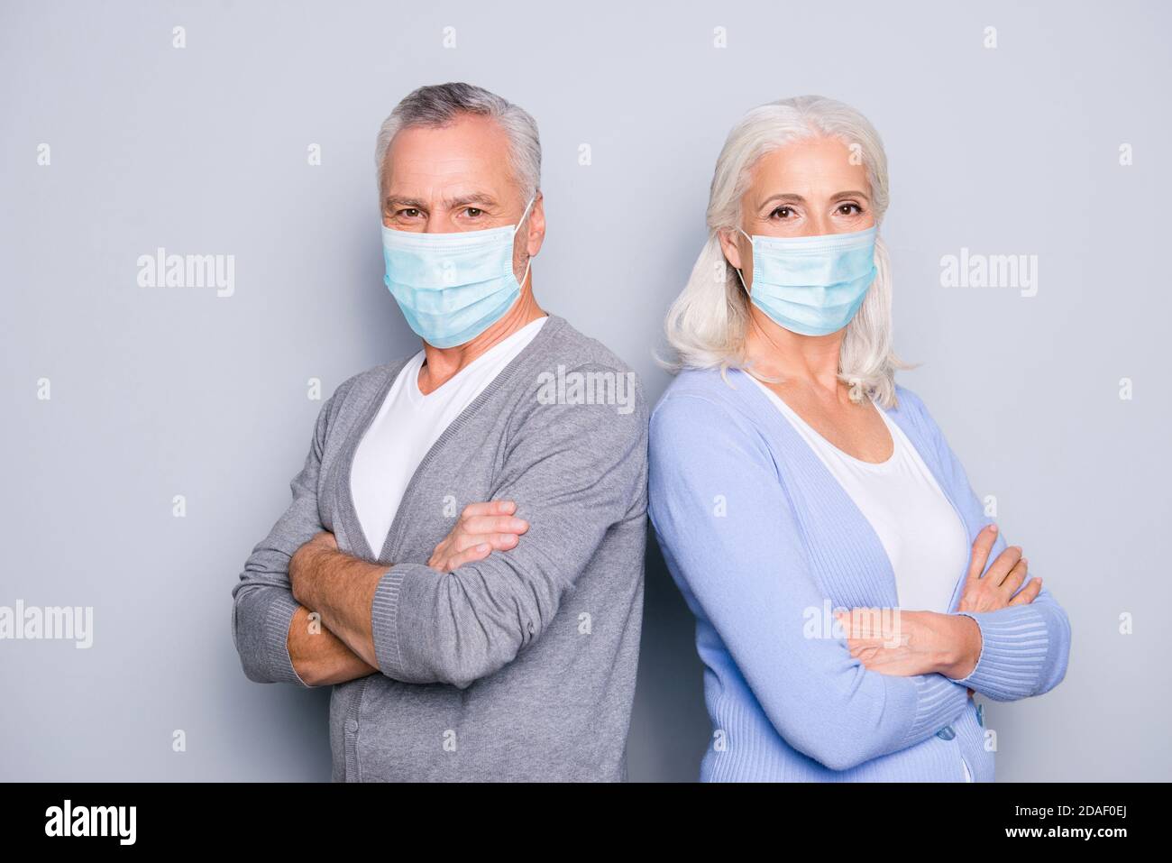 Photo portrait of old man and woman standing back to back with folded ...