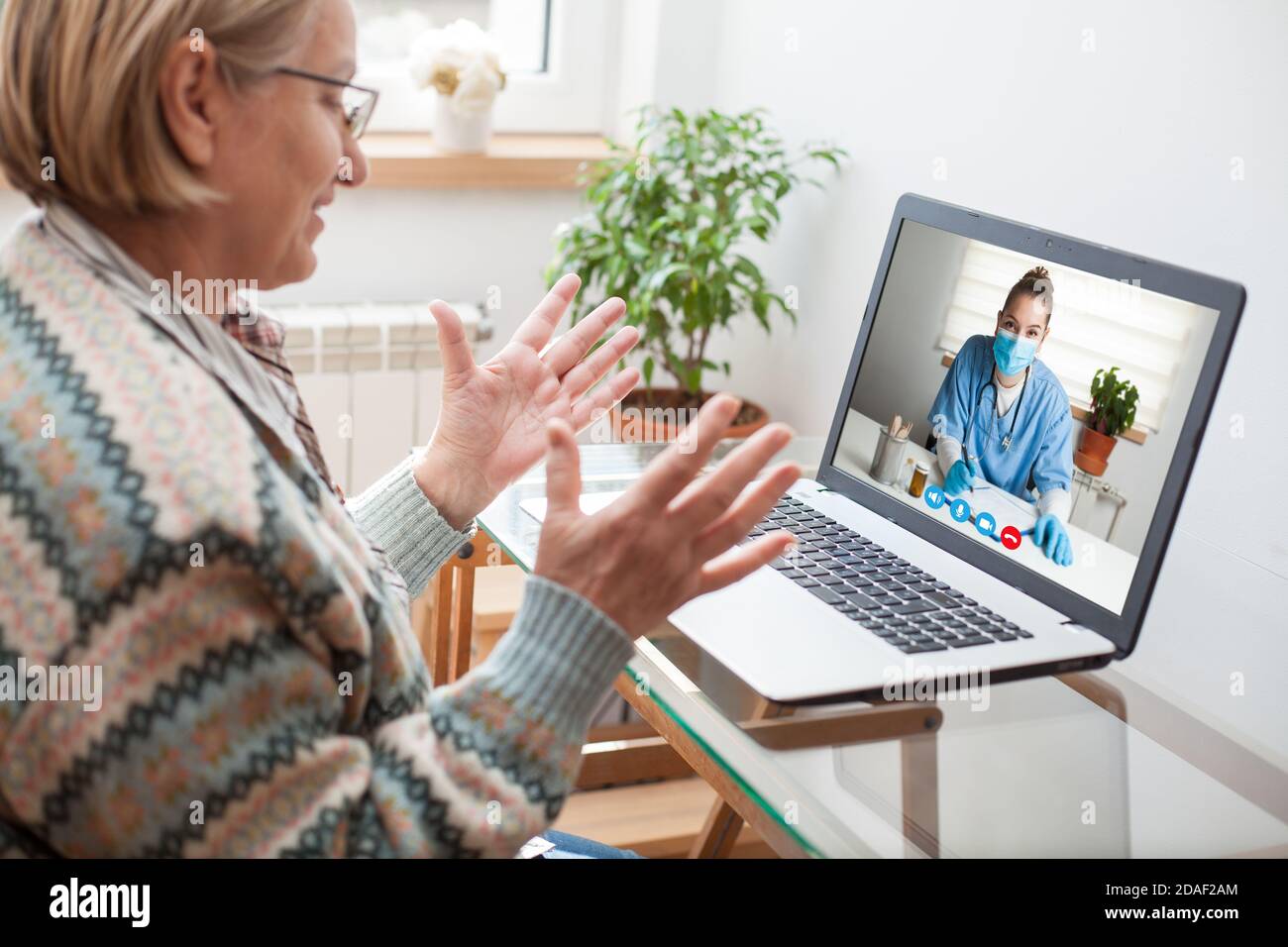 Elderly caucasian woman interacting with young female doctor via video ...