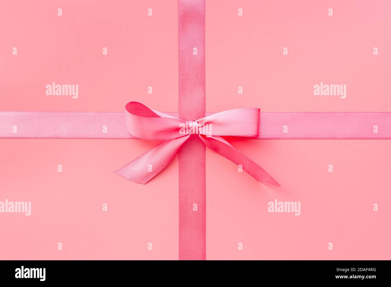 Pink ribbon with bow for holiday gift box or greeting card banner. Top ...