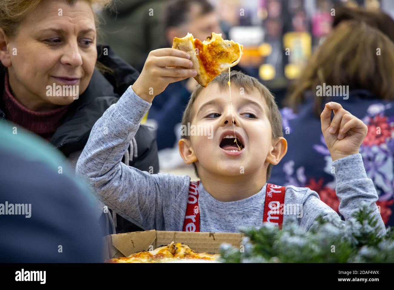 Cute kid boy eating made pizza in the cafe: Russia. Moscow 20 December ...