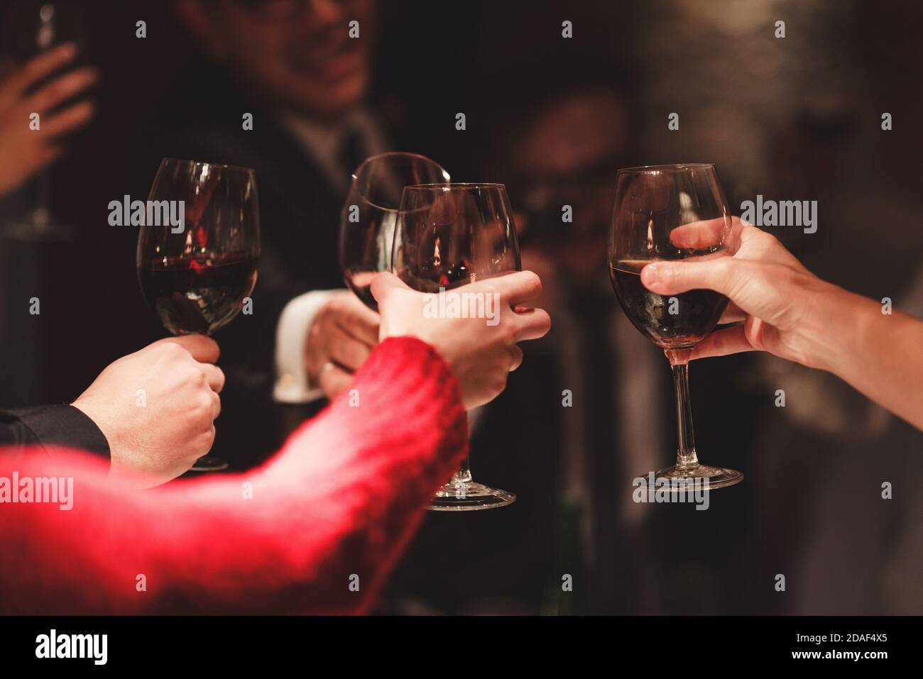 Hands of people with glasses of wine, celebrating and toasting in honor ...