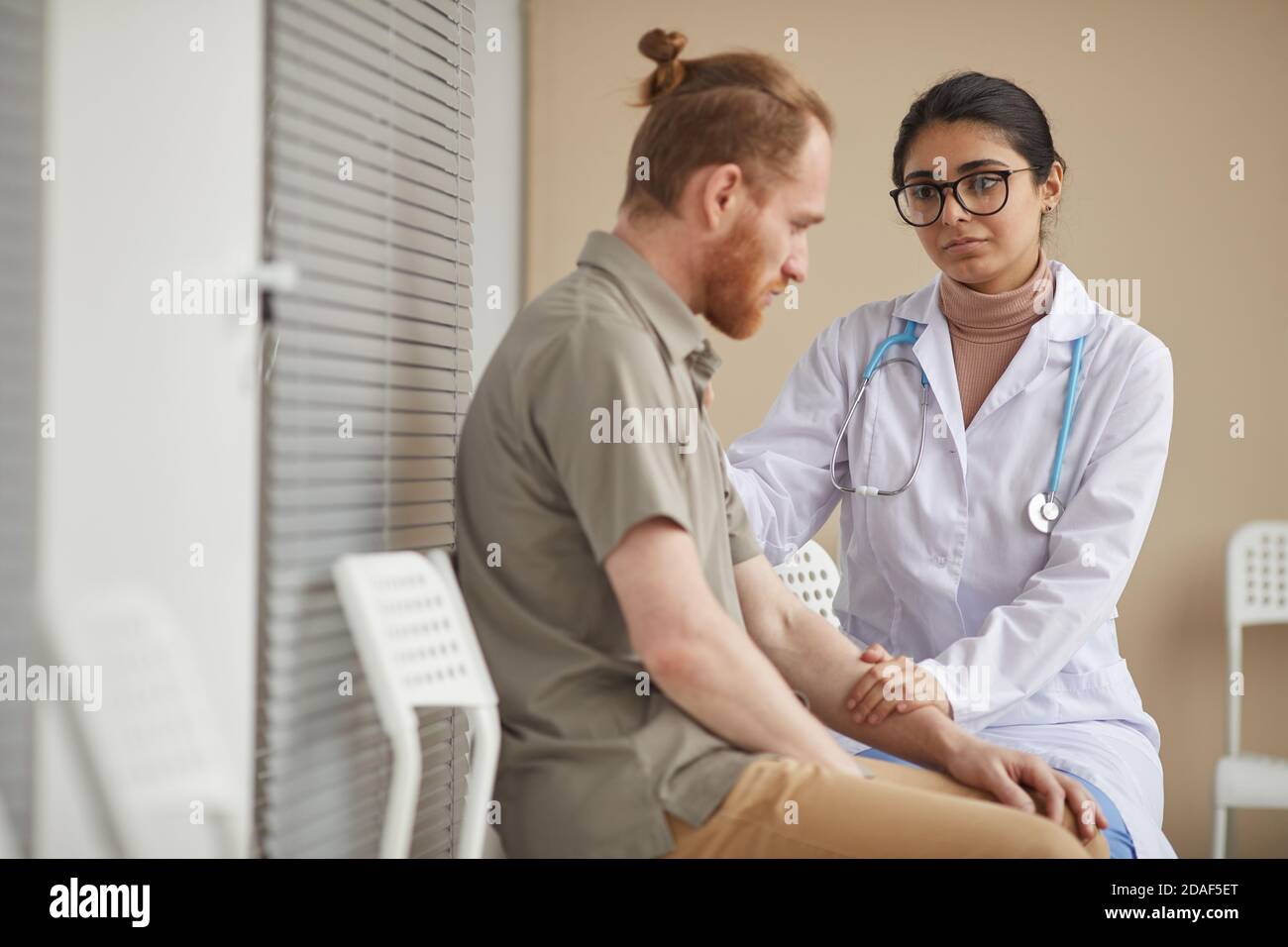 Male patient upset by doctor's news while they sitting at the corridor ...