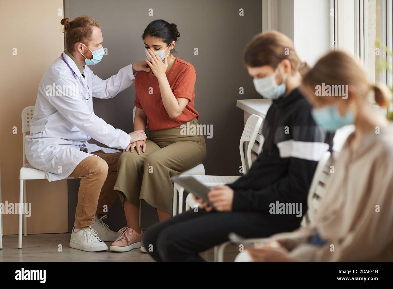 Male doctor supporting the patient while she crying they sitting at the ...