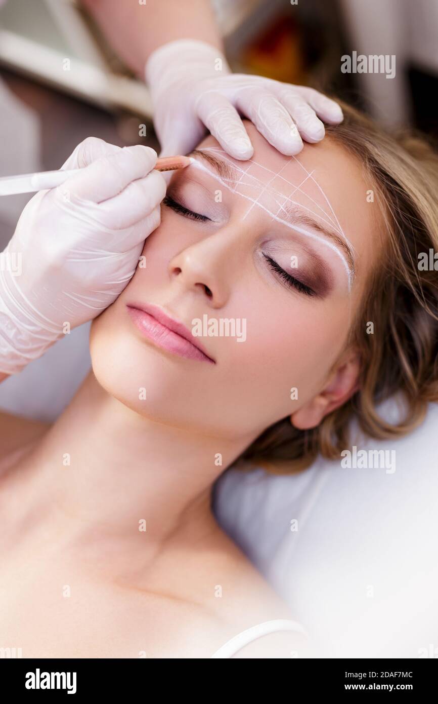make up and beauty concept - close up portrait of cosmetologist drawing ...