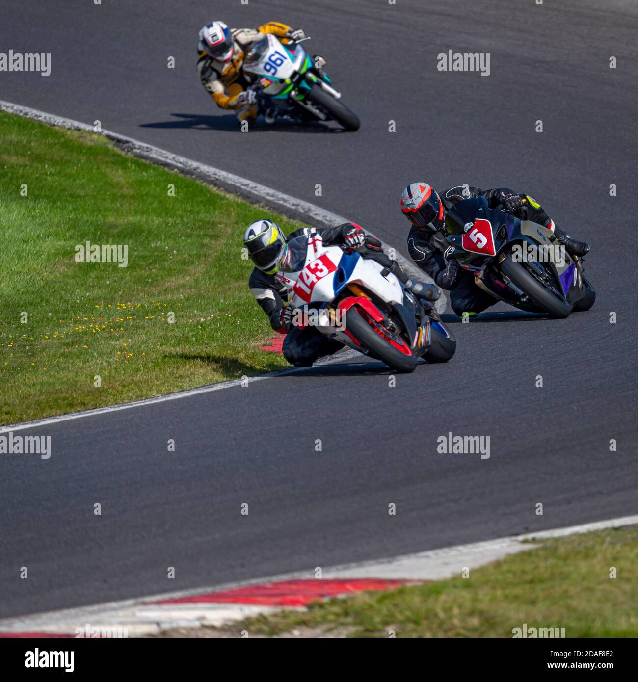 A shot of several racing bikes cornering on a track Stock Photo - Alamy