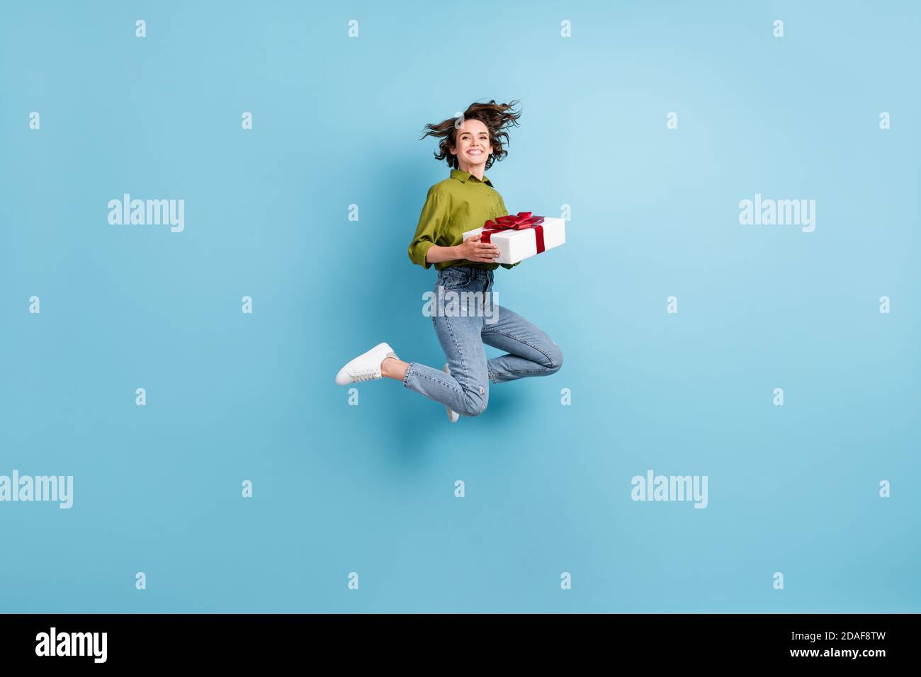 Photo portrait of girl jumping up holding white red present in hands ...