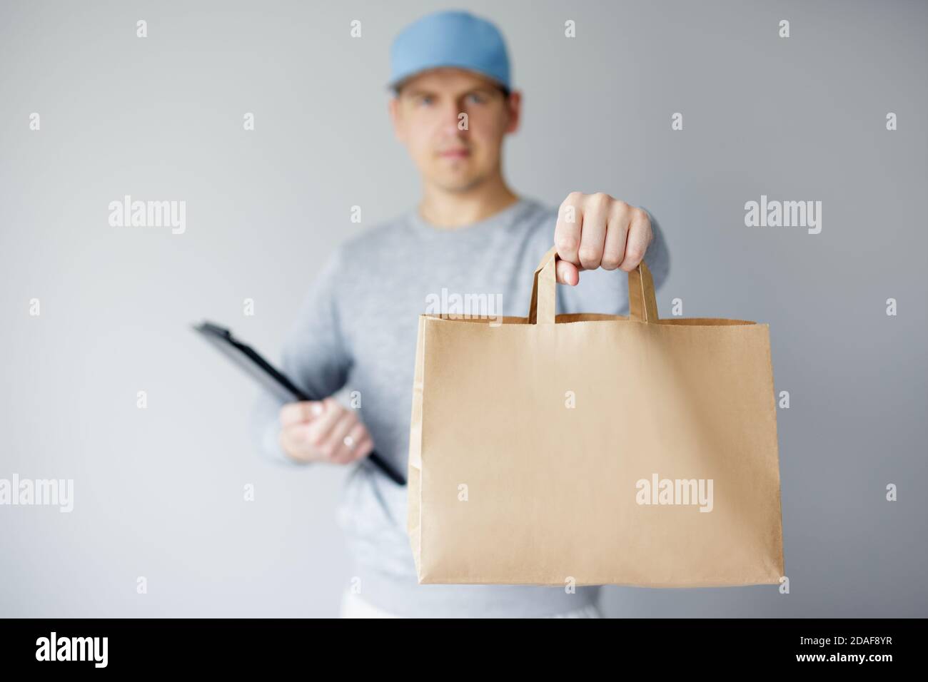 close up of delivery man giving fast food order over white background ...