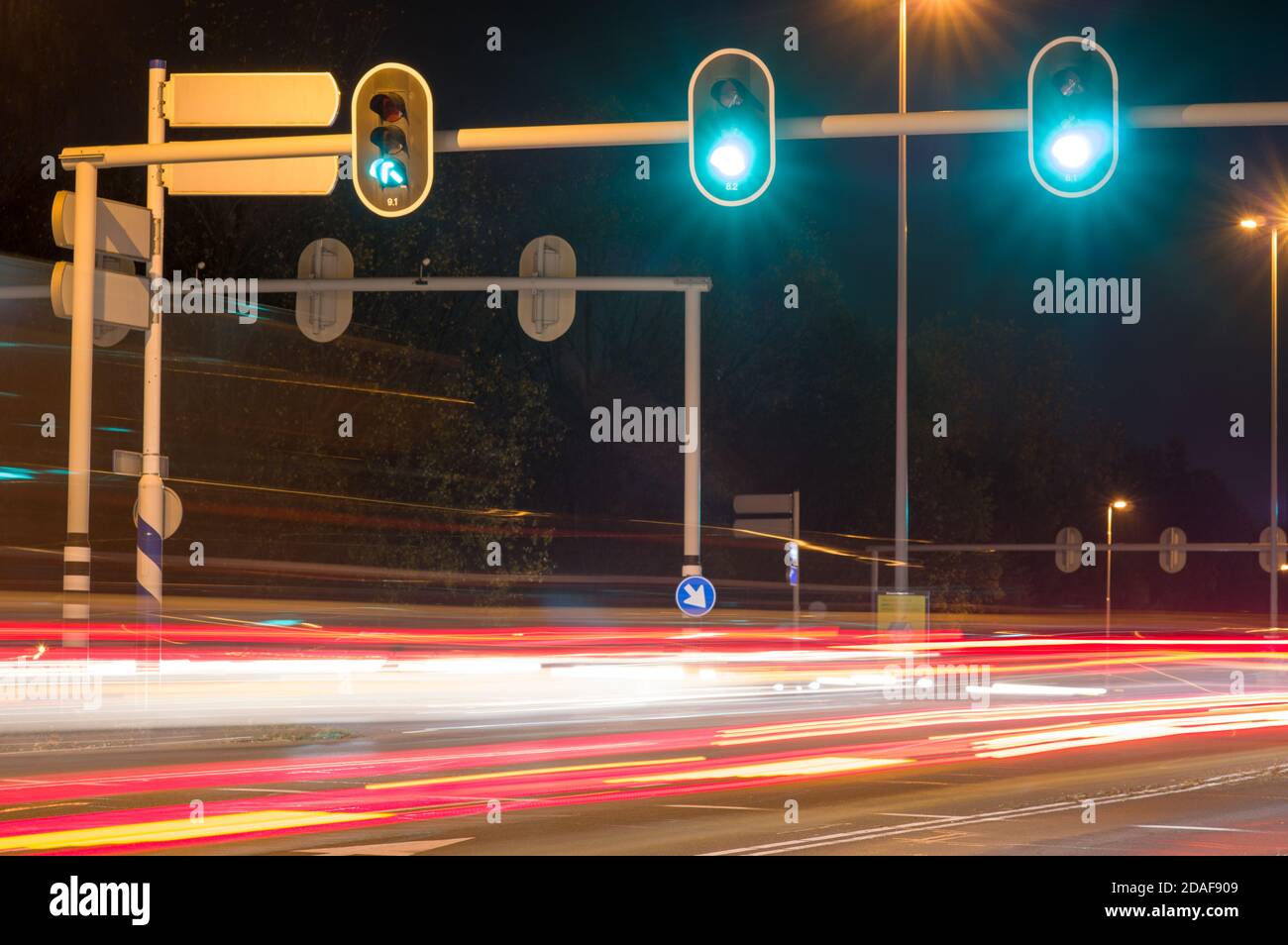 Intersection at night with traffic lights and traffic blurred by motion ...