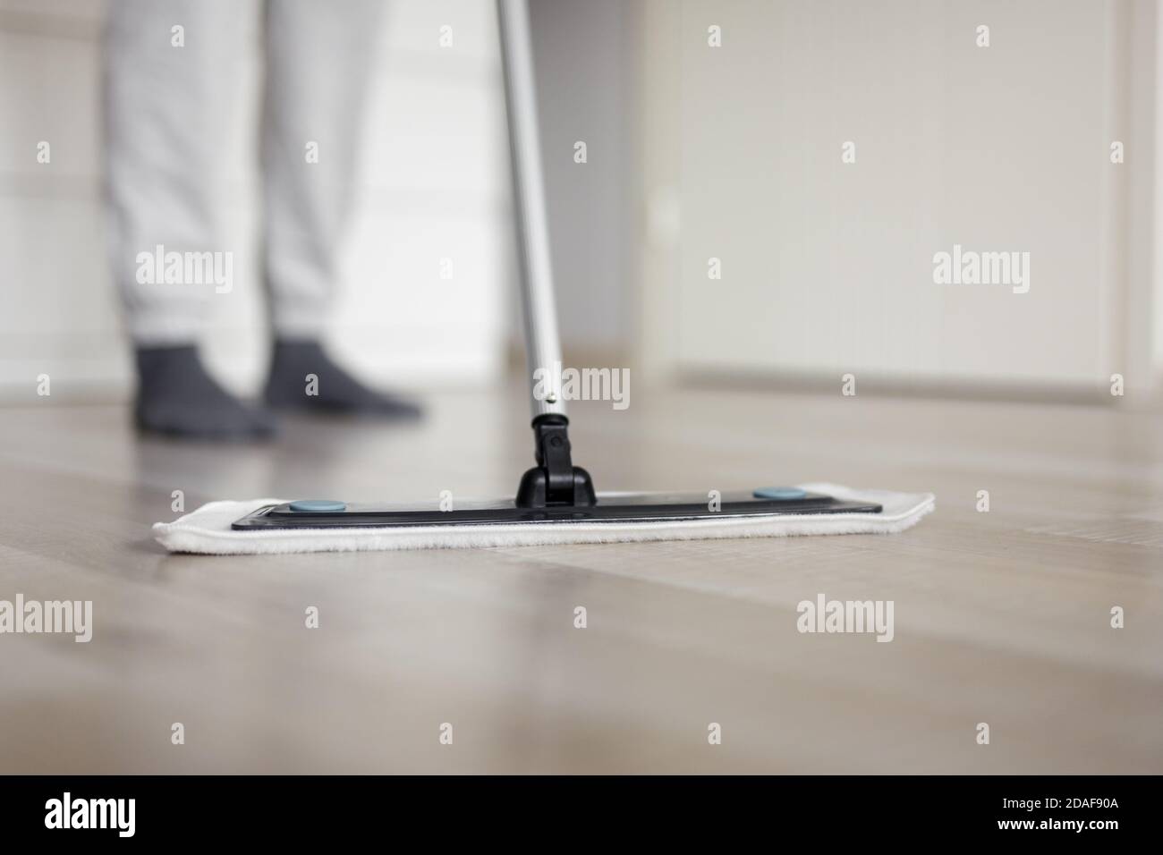 housekeeping concept - close up of modern mop cleaning wooden floor at ...