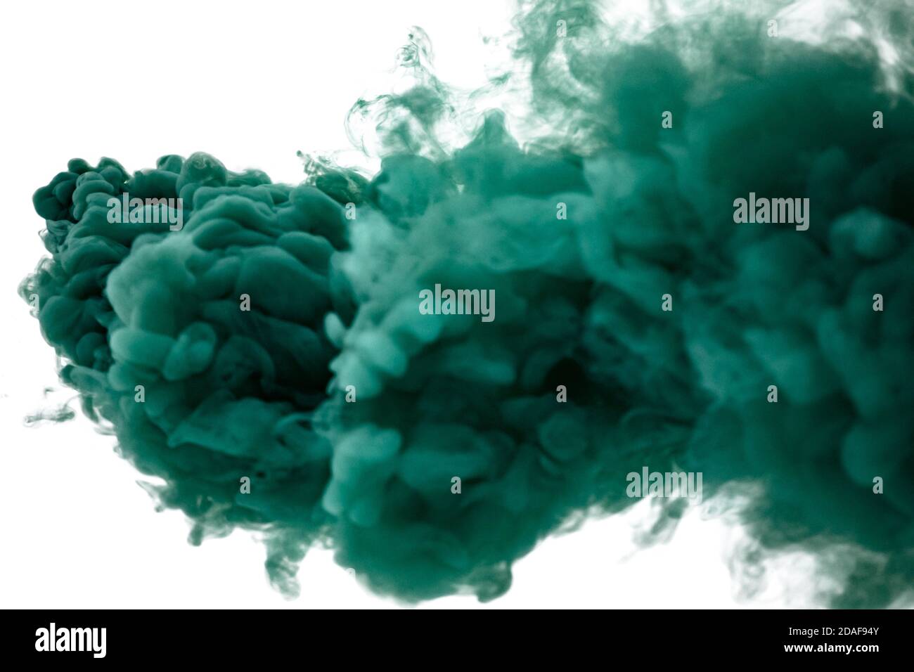 Green smoke bomb exploding against white background Stock Photo - Alamy