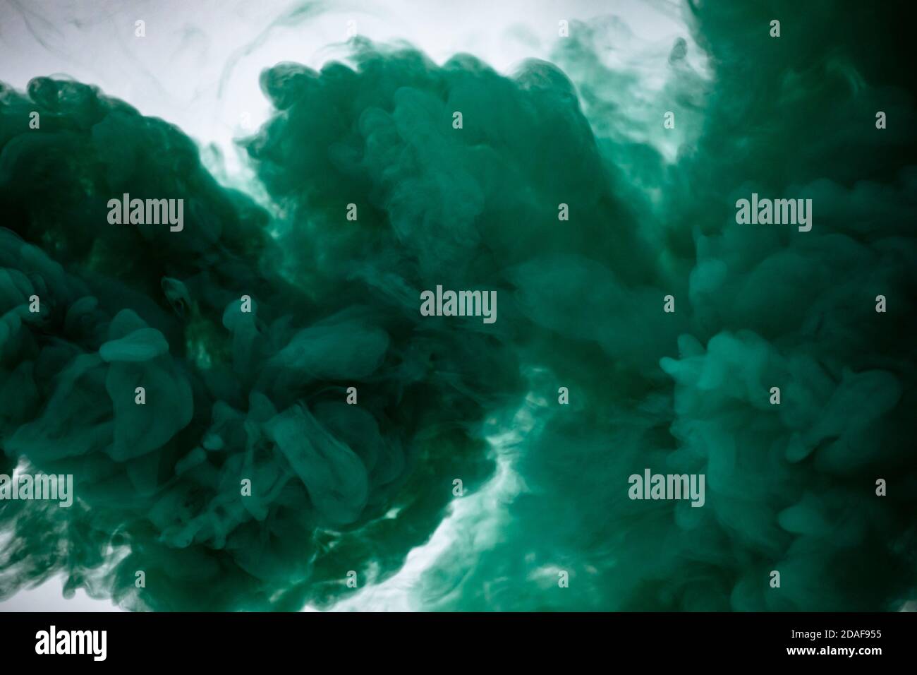 Green smoke bomb exploding against white background Stock Photo - Alamy