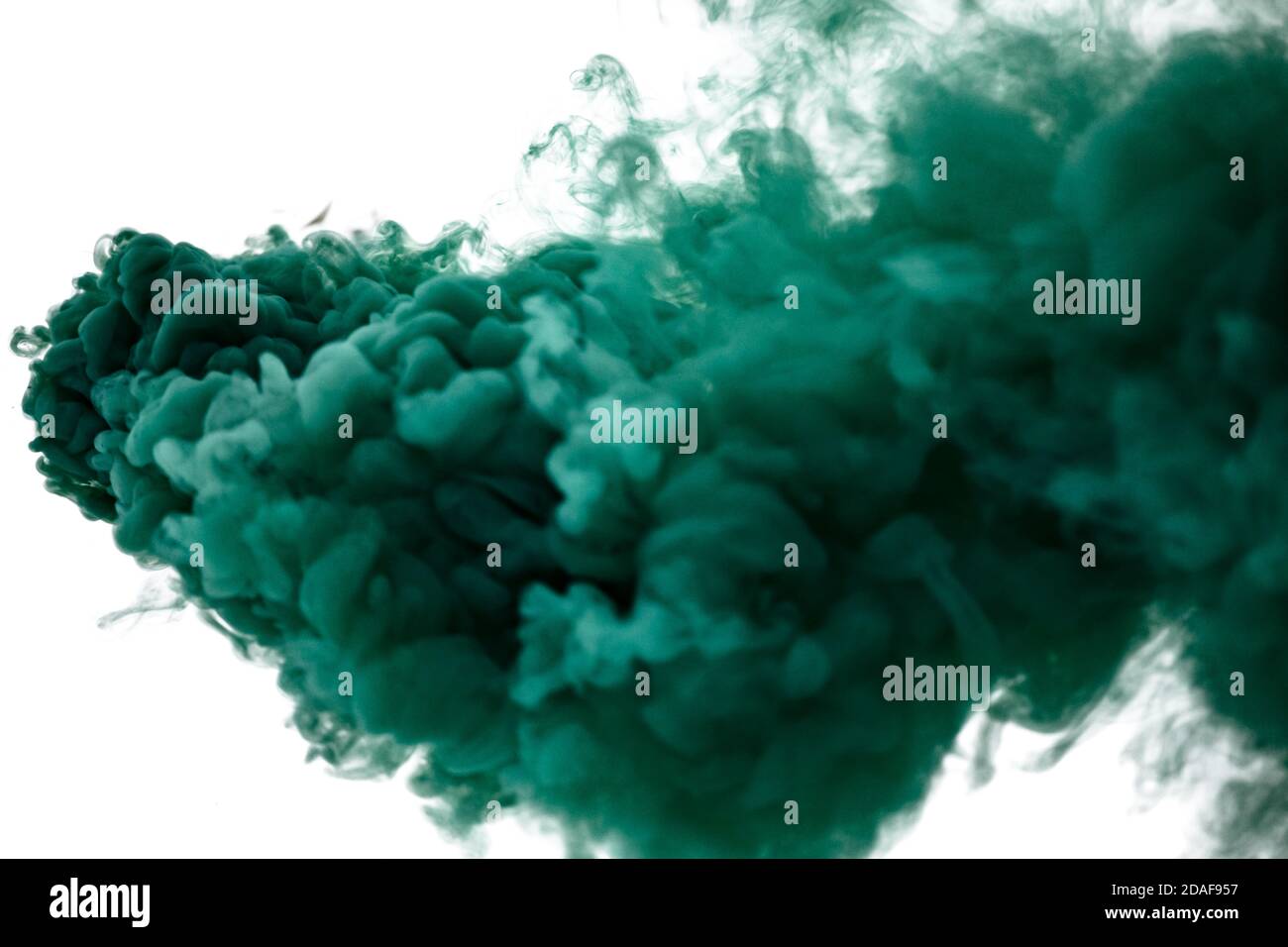 Green smoke bomb exploding against white background Stock Photo - Alamy