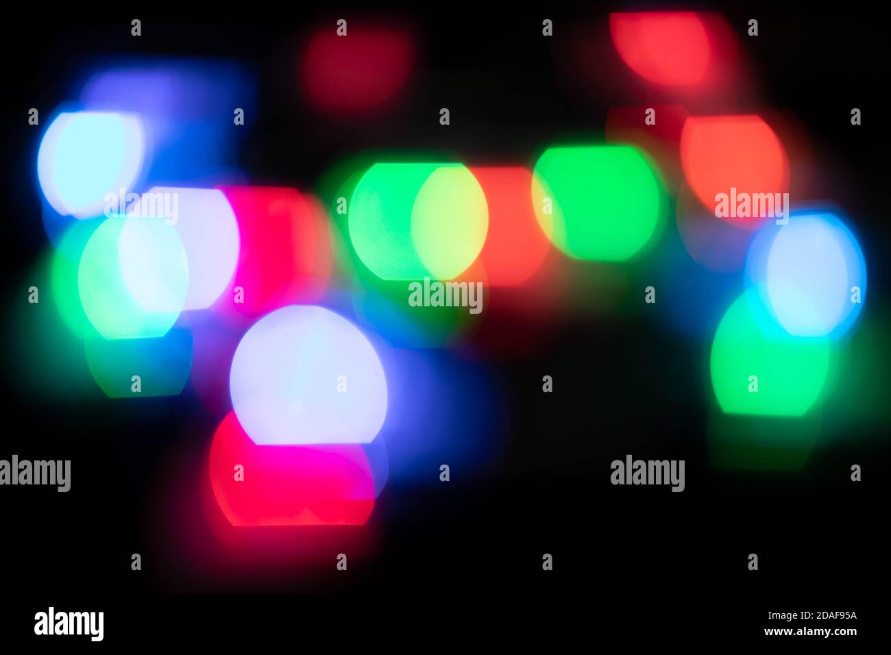 Multicolored spots of light against black background Stock Photo - Alamy