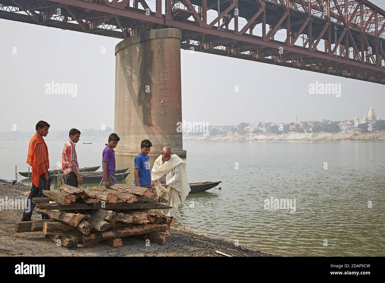 Varanasi, India, December 2015. Men prepare a funeral pyre near a ...