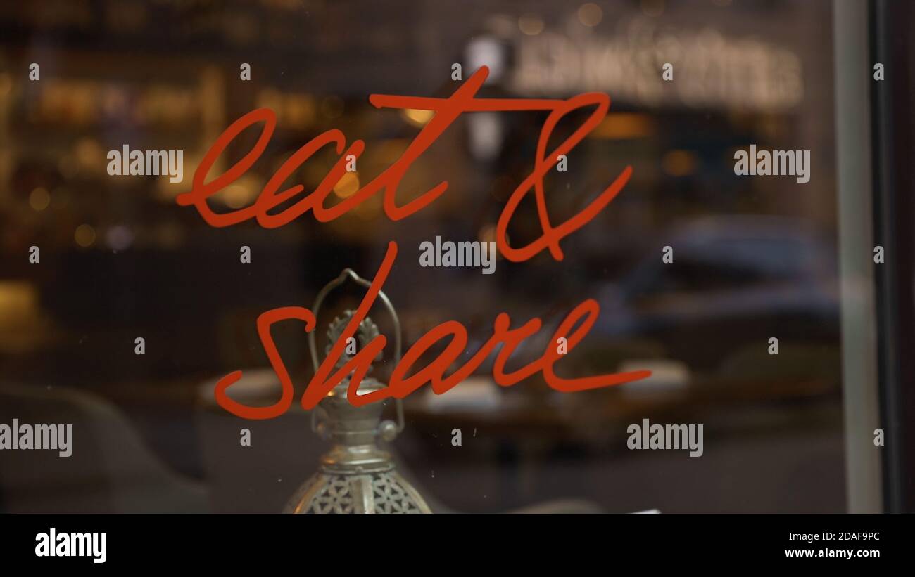 Eat and Share sign on restaurant glass display Stock Photo - Alamy