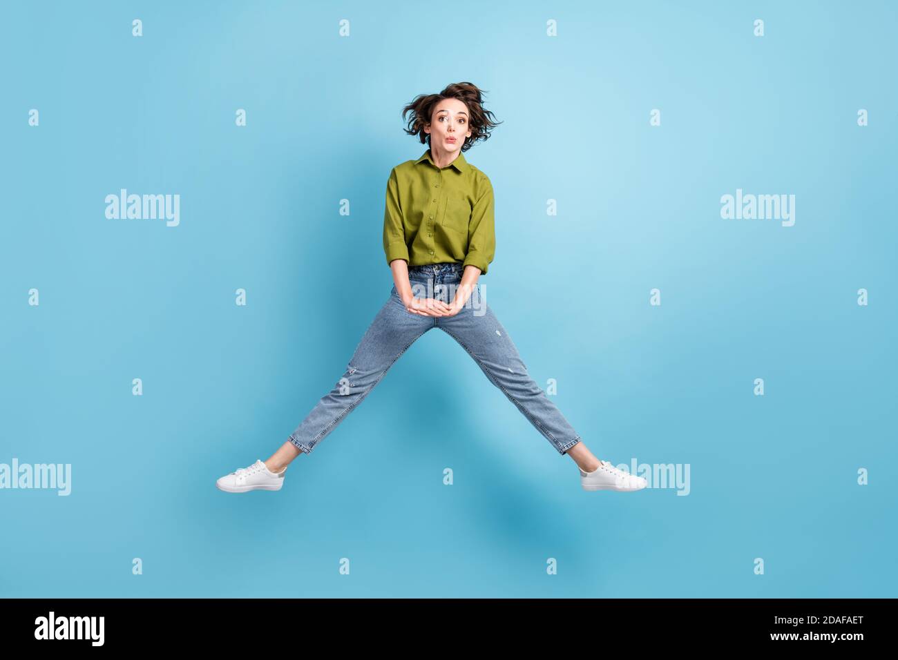 Photo portrait of surprised woman jumping up spread legs isolated on ...