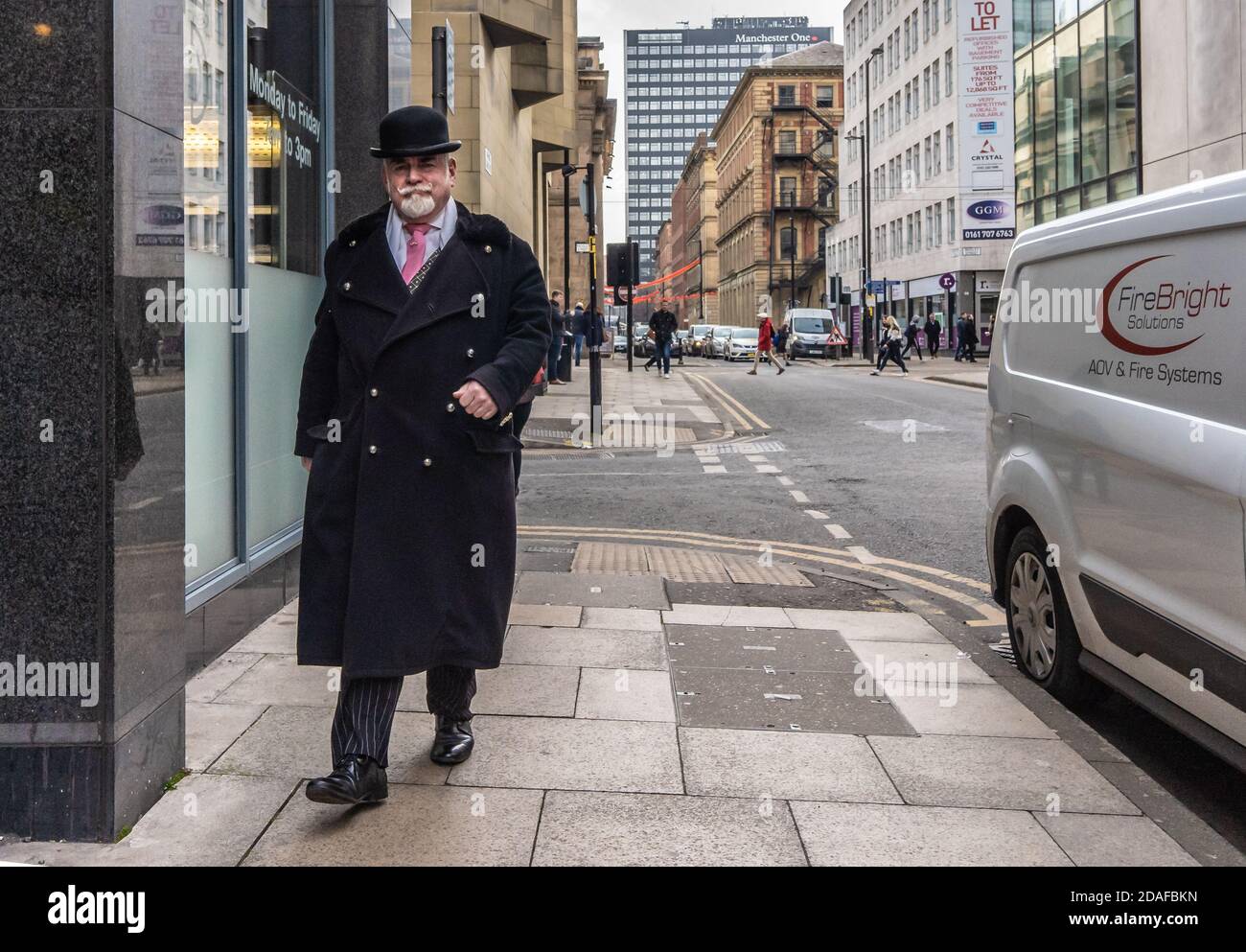 An immaculately dressed older gentleman walks down the street in ...