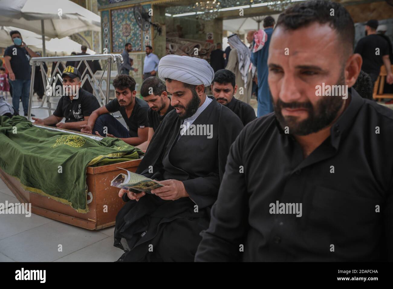 Najaf, Iraq. 12th Nov, 2020. People pray next to a coffin at the mosque ...