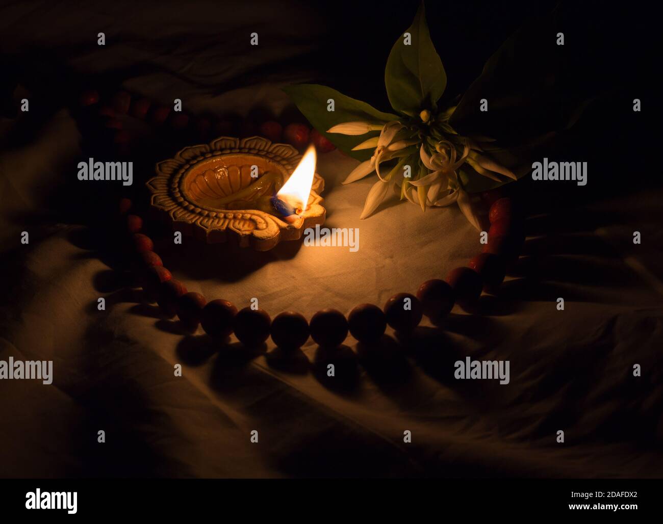 Indian traditional oil lamp made of clay with glowing flame, jasmine ...