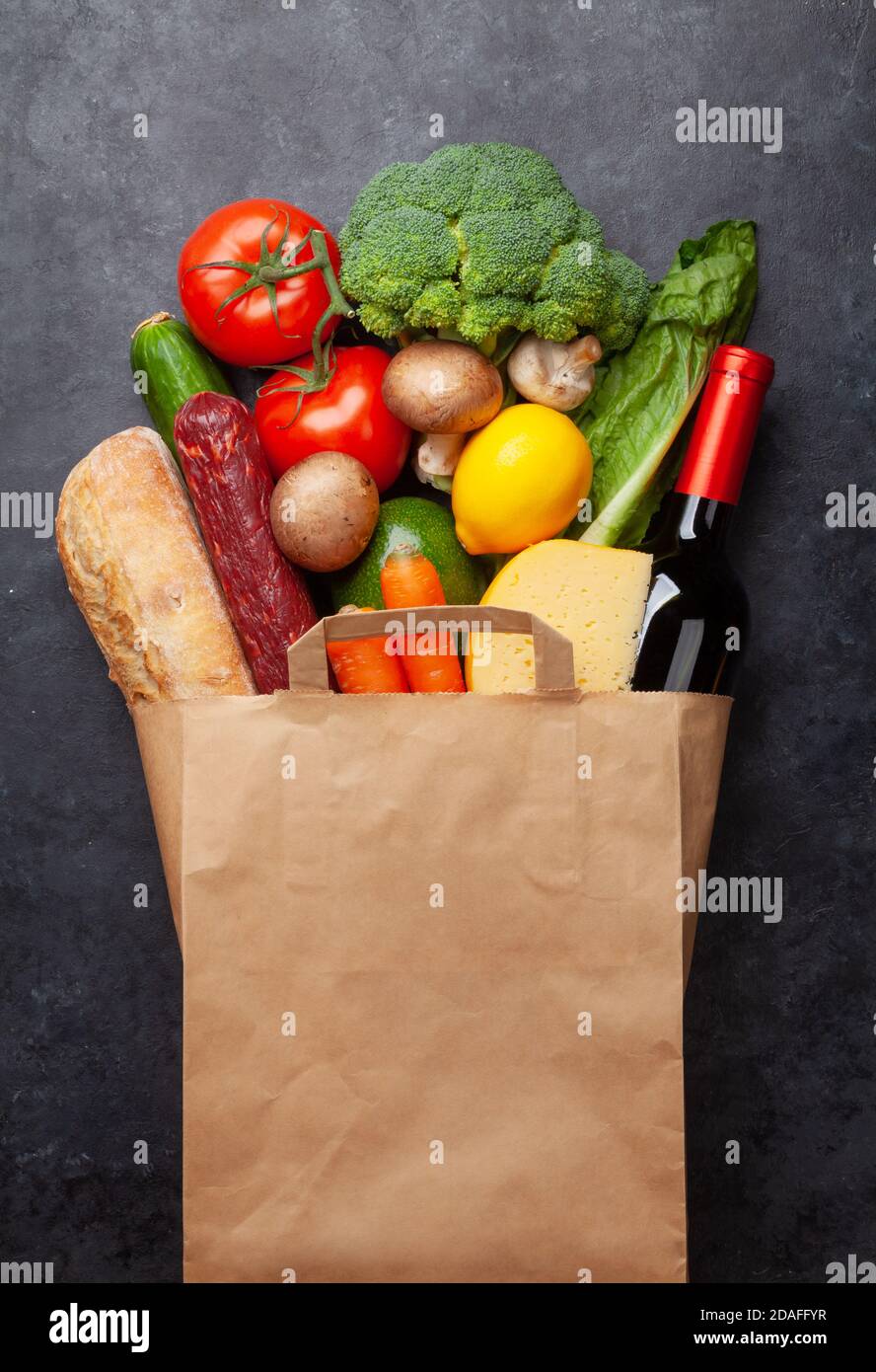Different food in recycling paper bag on stone table. Top view flat lay ...