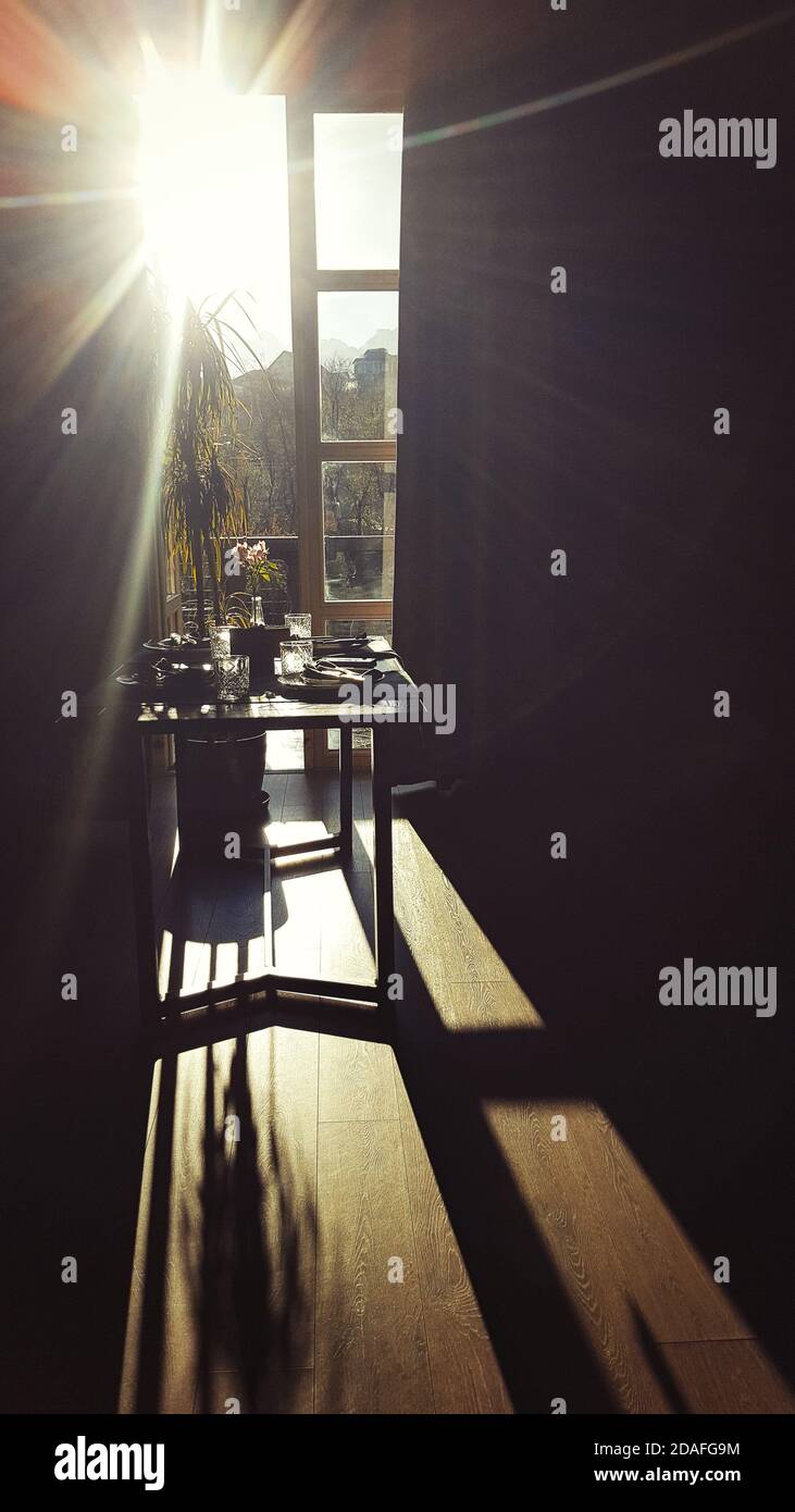 Table setting for breakfast in the morning sun through a French window ...