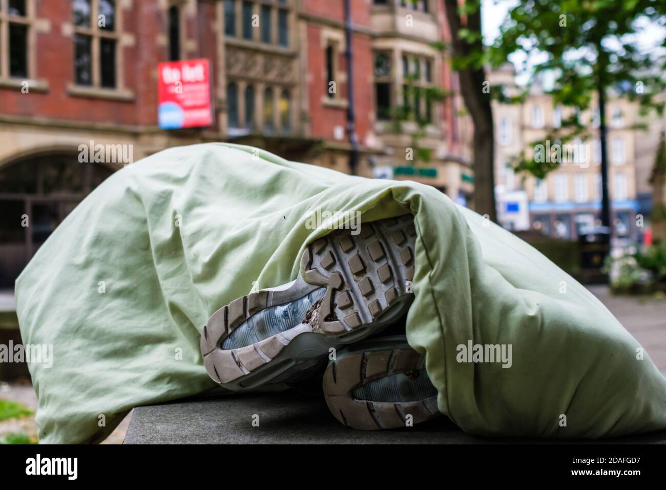 The feet of a rough sleeper on a bench in Sheffield Stock Photo - Alamy
