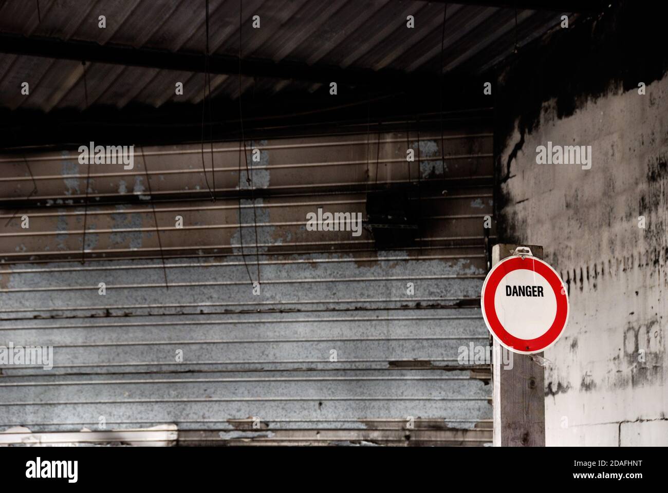 Devastated, ancient building with metallic, partially burned curtain ...