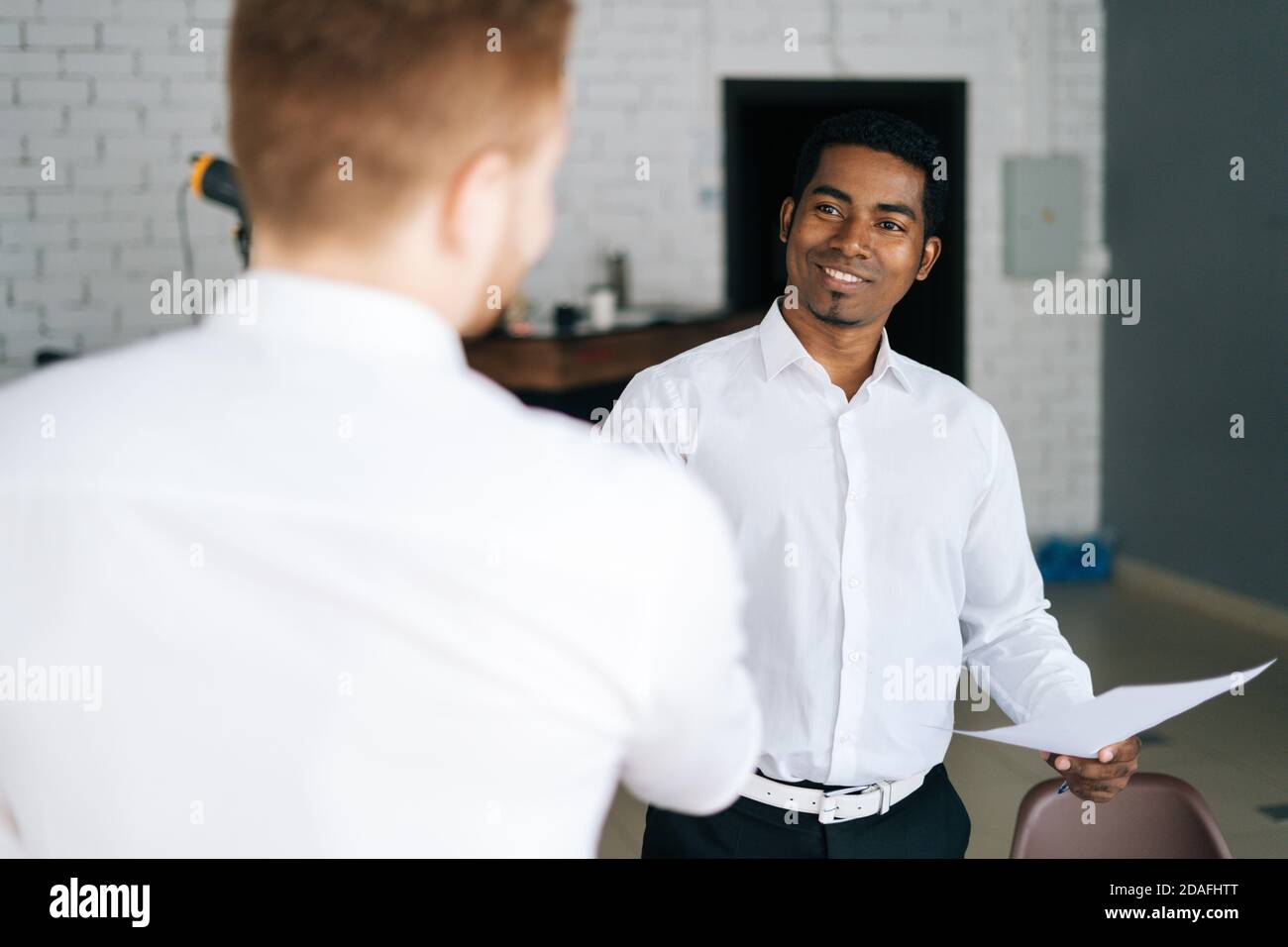 Back view of Caucasian businessman and African business man signing ...