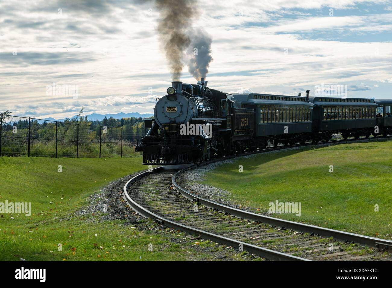 Old, antique steam train running down the track, Heritage Park Calgary ...