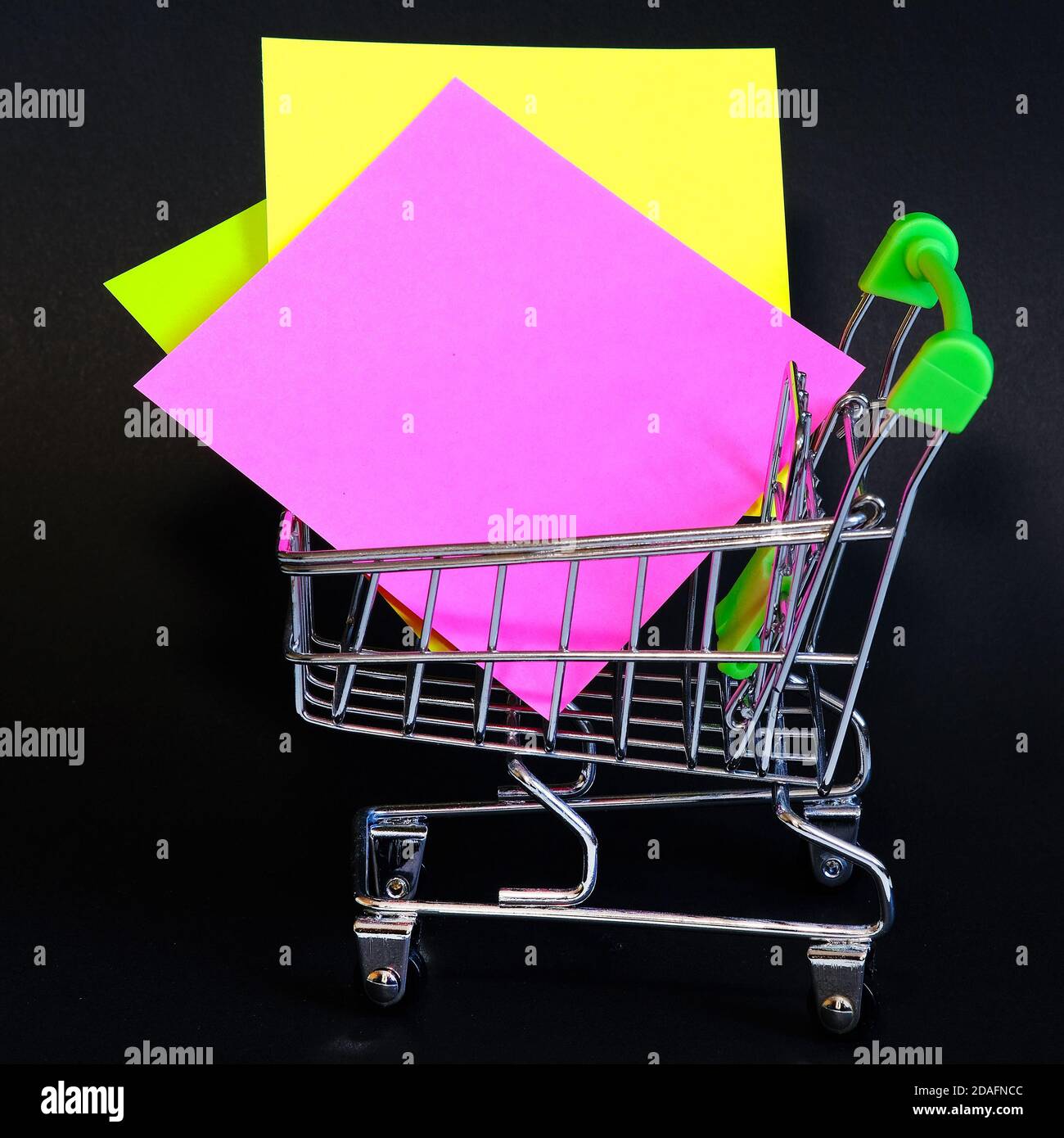 Colorful notes isolated on a black background. In the office basket ...