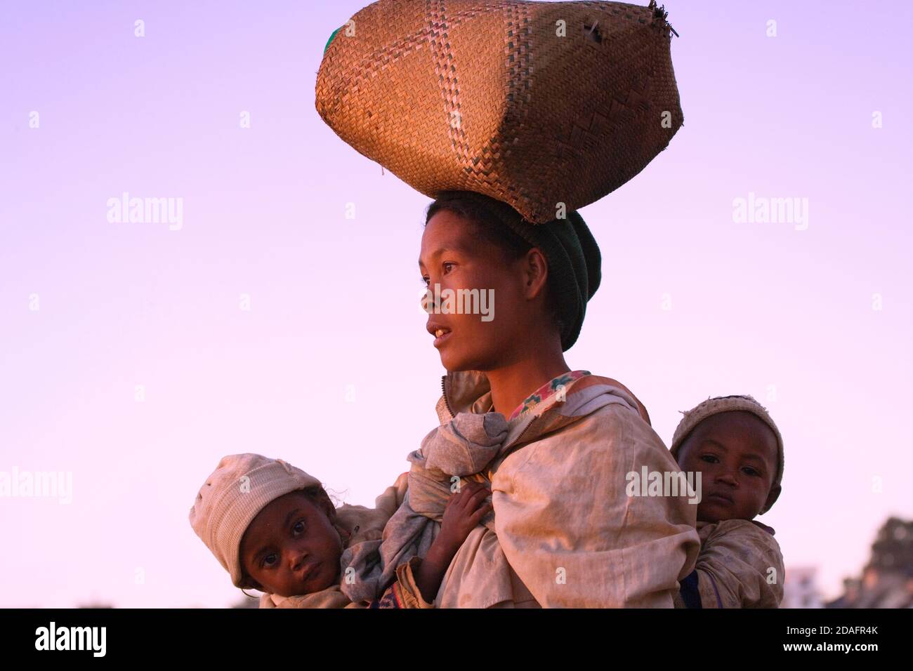 Woman carrying babies and load on head, Antananarivo, Madagascar Stock ...
