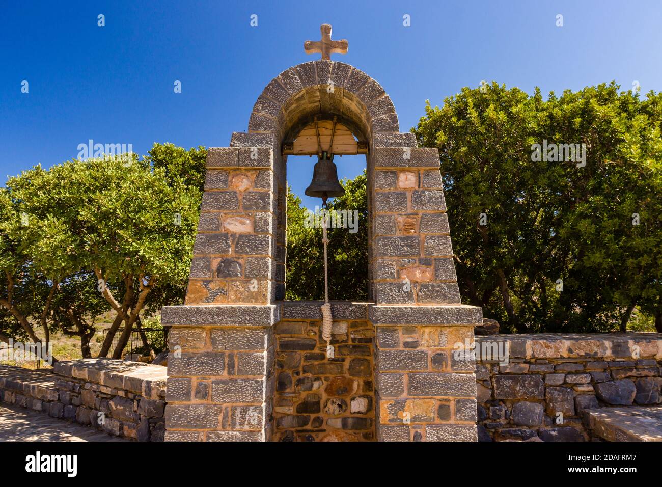 Outside bell and cross at a small, traditional Greek church on the ...
