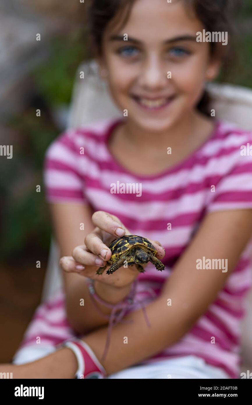 Little girl with a turtle on her hands. Focus on girl Stock Photo - Alamy