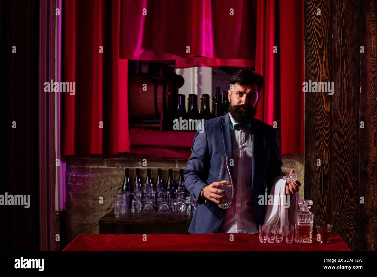 Waiter bartender. Handsome bearded barman leaning on bar counter ...