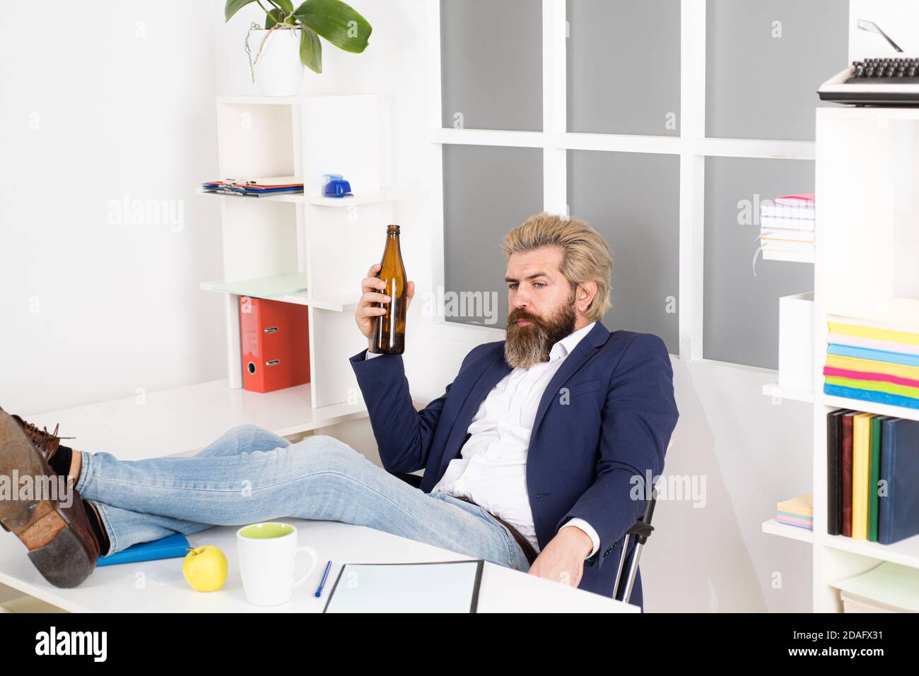 End of the working day. Young businessman employee drinking in the ...