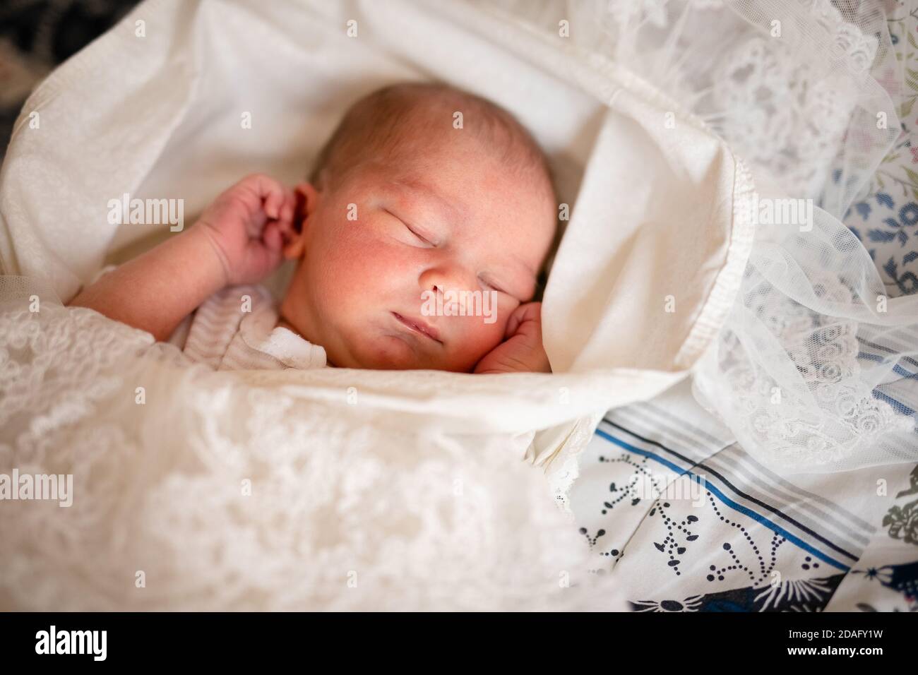 Newborn baby boy in bed. New born child in white bodykit lying in light ...