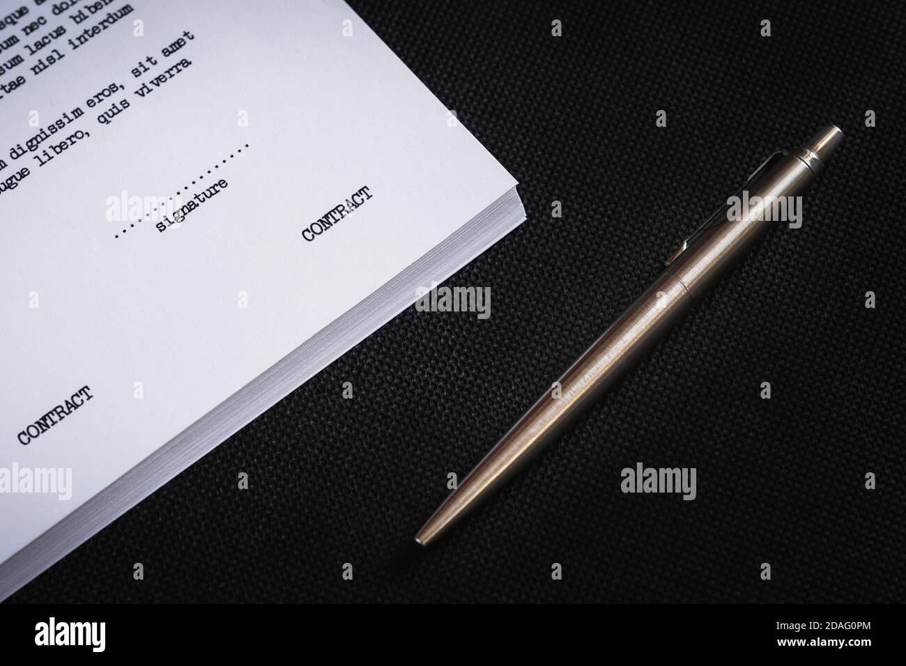 Picture of thick contract with dummy text and ball point pen to sign it ...