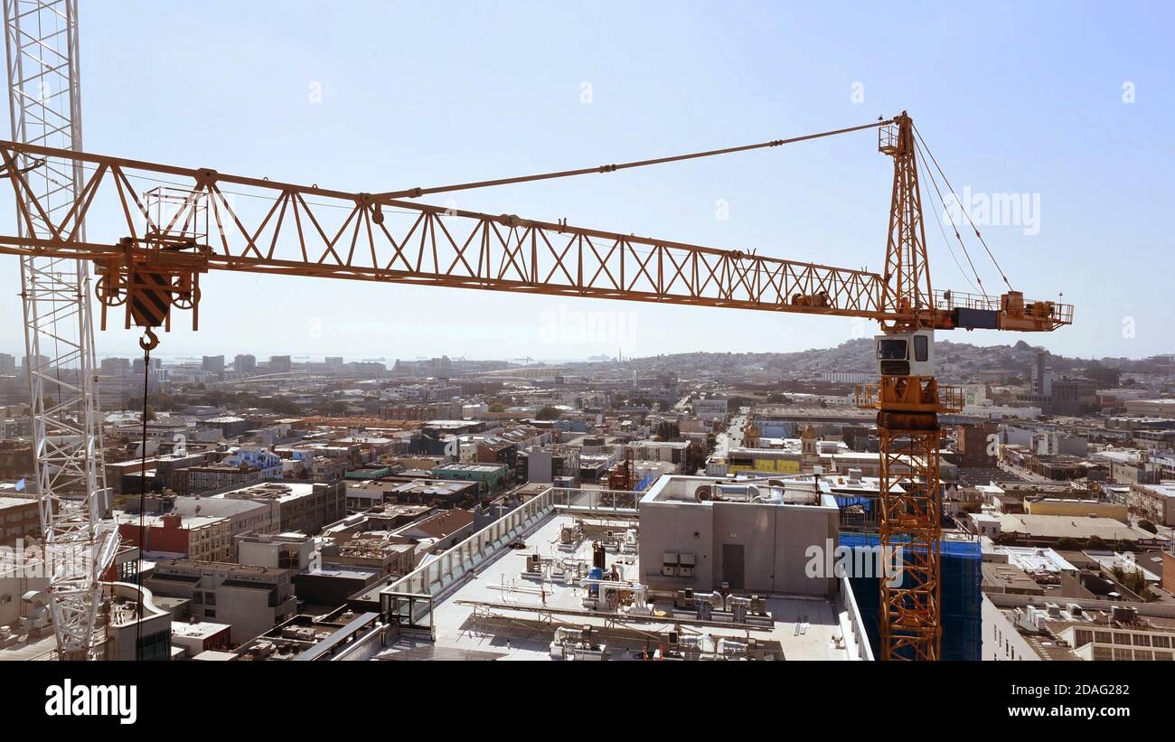 Industrial construction cranes with the city in background Stock Photo ...