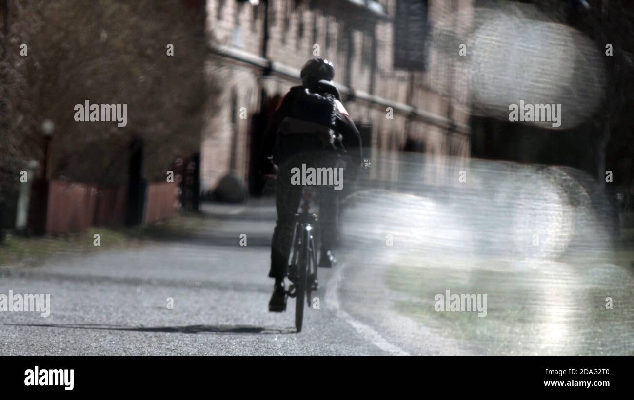 rear view of a person riding bicycle in city, with motion blur effect ...