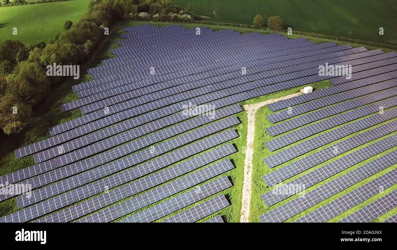 Solar panels cells in solar energy farm between green fields Stock ...