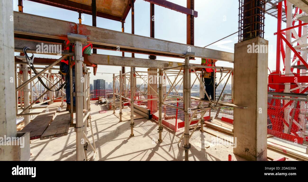 high building under construction with workers in the construction site ...