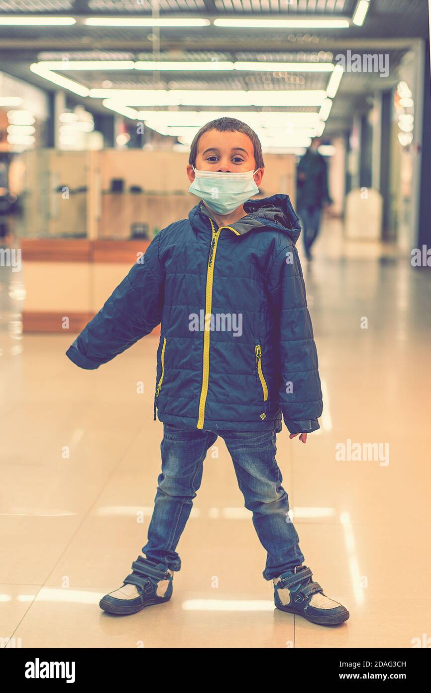 Toddler child, boy, wearing protective medical mask in shopping center ...