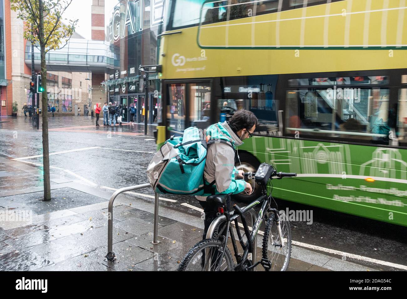 Deliveroo rider, courier with bike in the rain in Newcastle upon Tyne ...