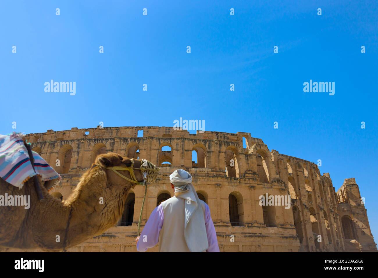 Man with camel with Roman amphitheater, the third largest in the world ...