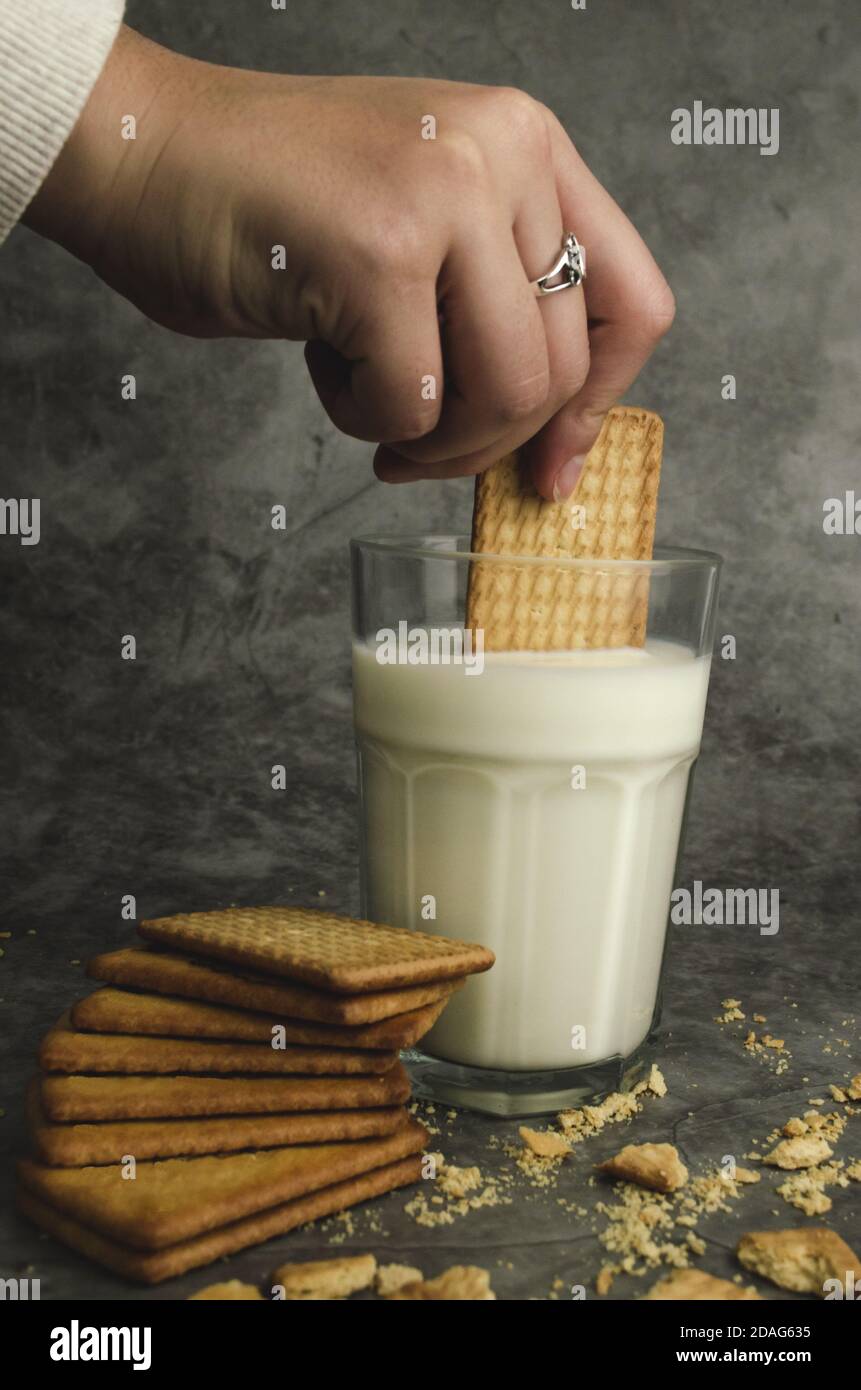 Vertical shot of a person eating biscuits and a glass of milk Stock ...