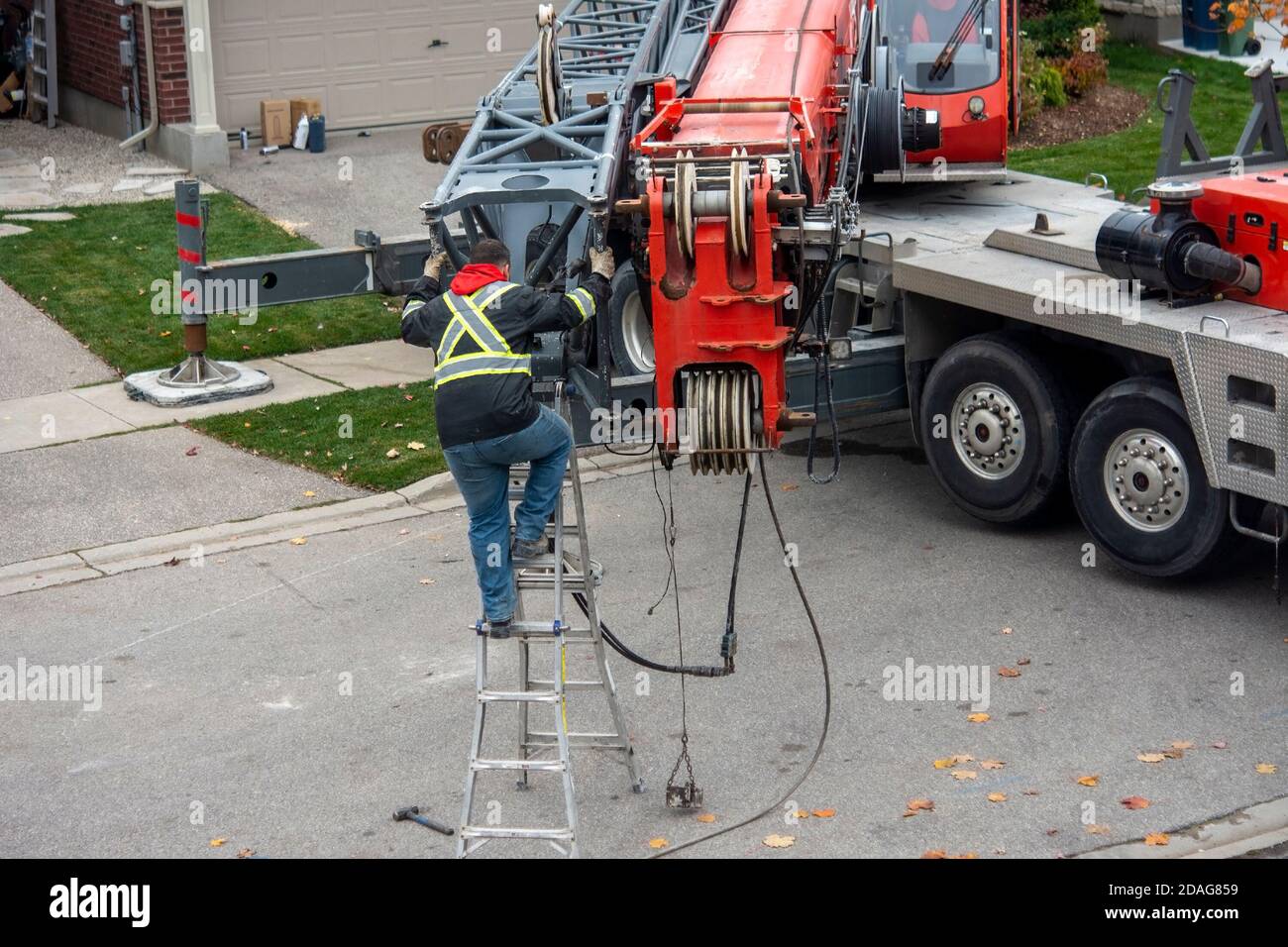 The crane operator prepares the crane for work, attaches an additional ...