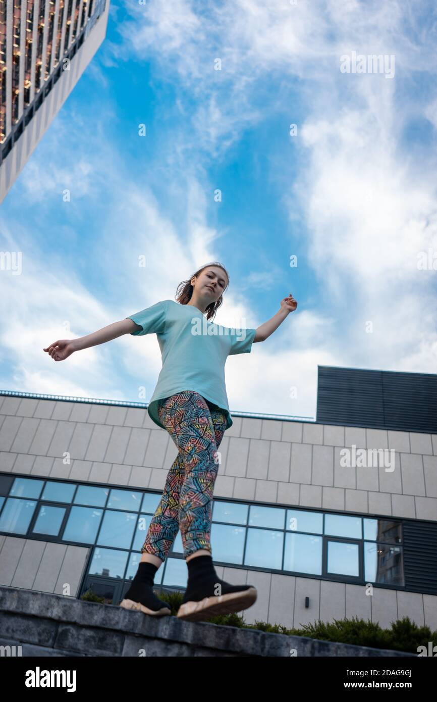 bottom view of stylish teenager near skyscraper walking outdoor Stock ...