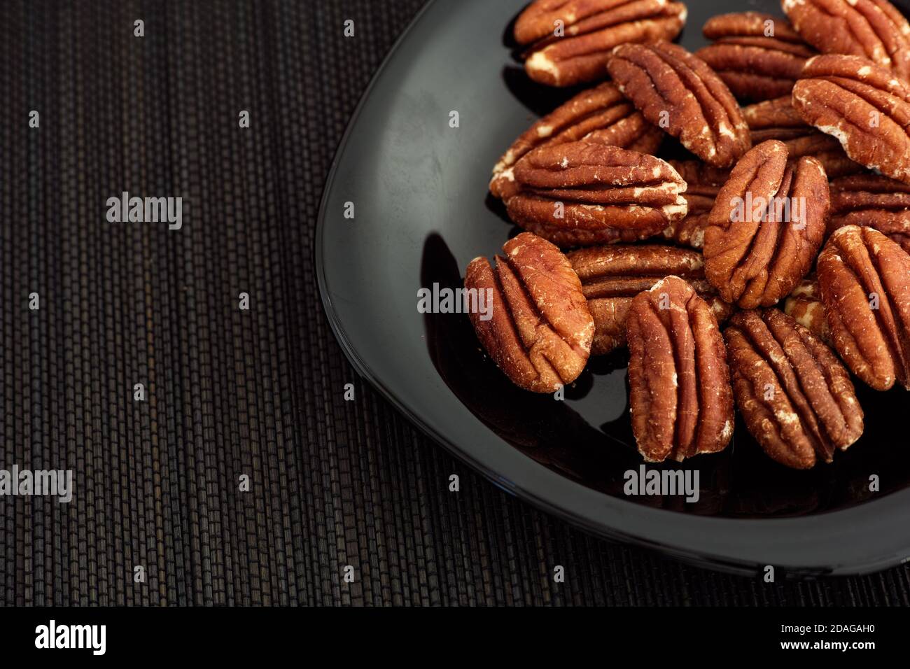 Pecan nuts in a plate. Low key. Close up Stock Photo - Alamy